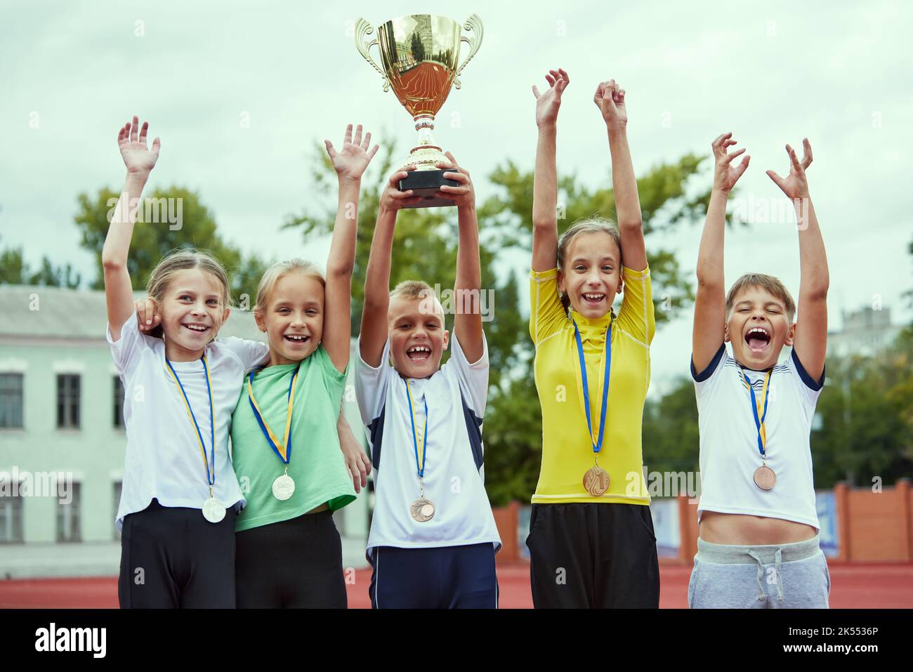 A boys and girls celebrating a victory. Motivated children team rising ...