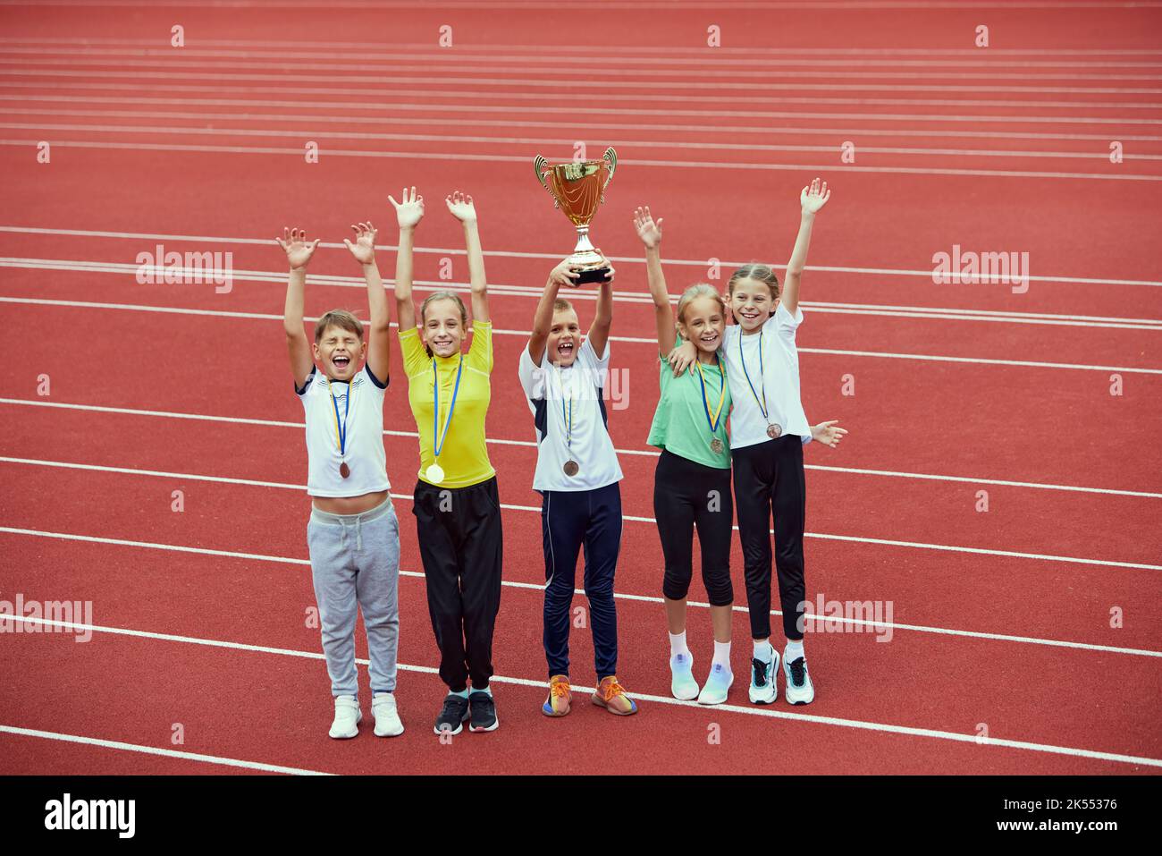 A boys and girls celebrating a victory. Motivated children team rising ...