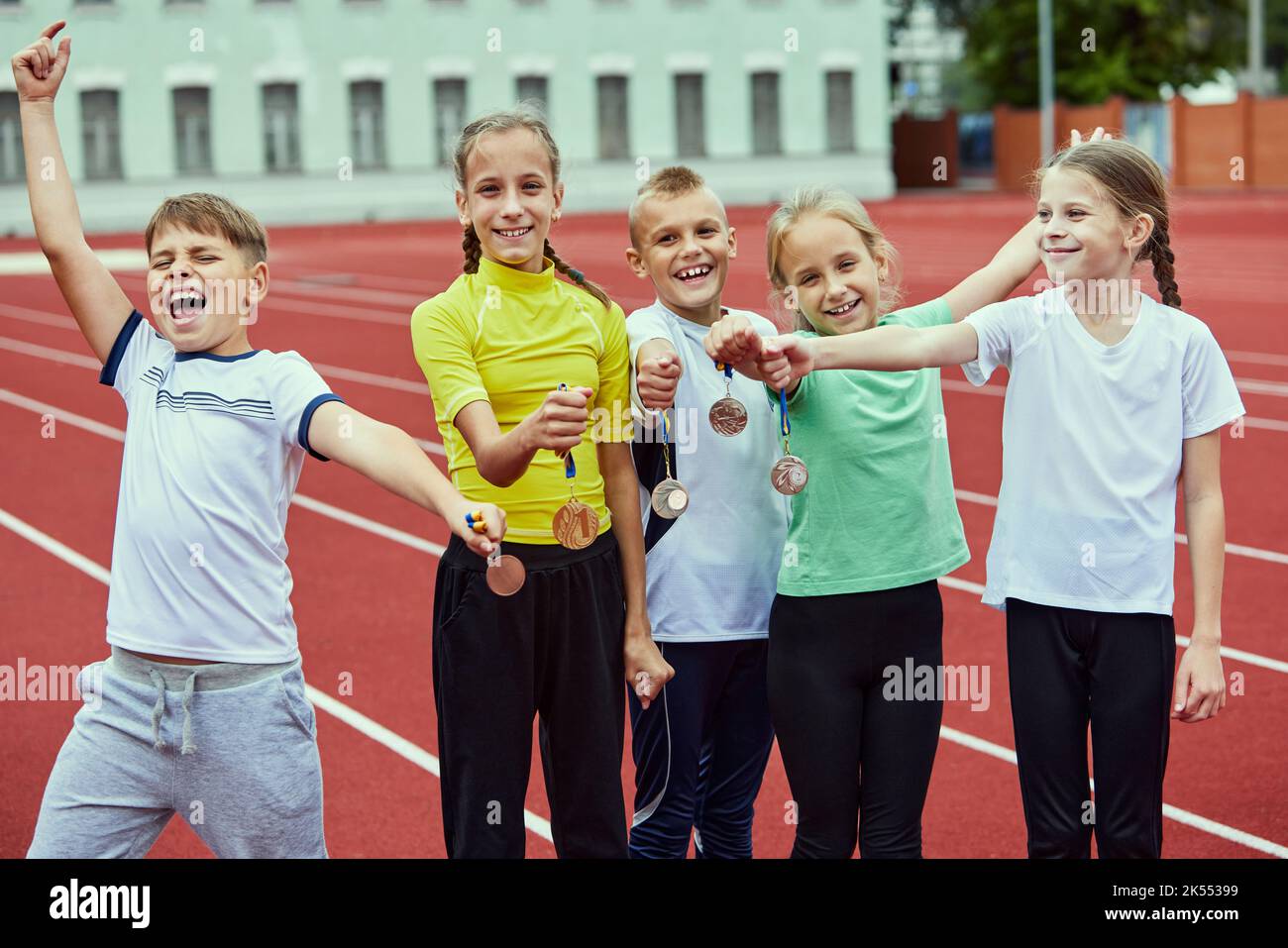 A boys and girls celebrating a victory. Motivated children team rising ...