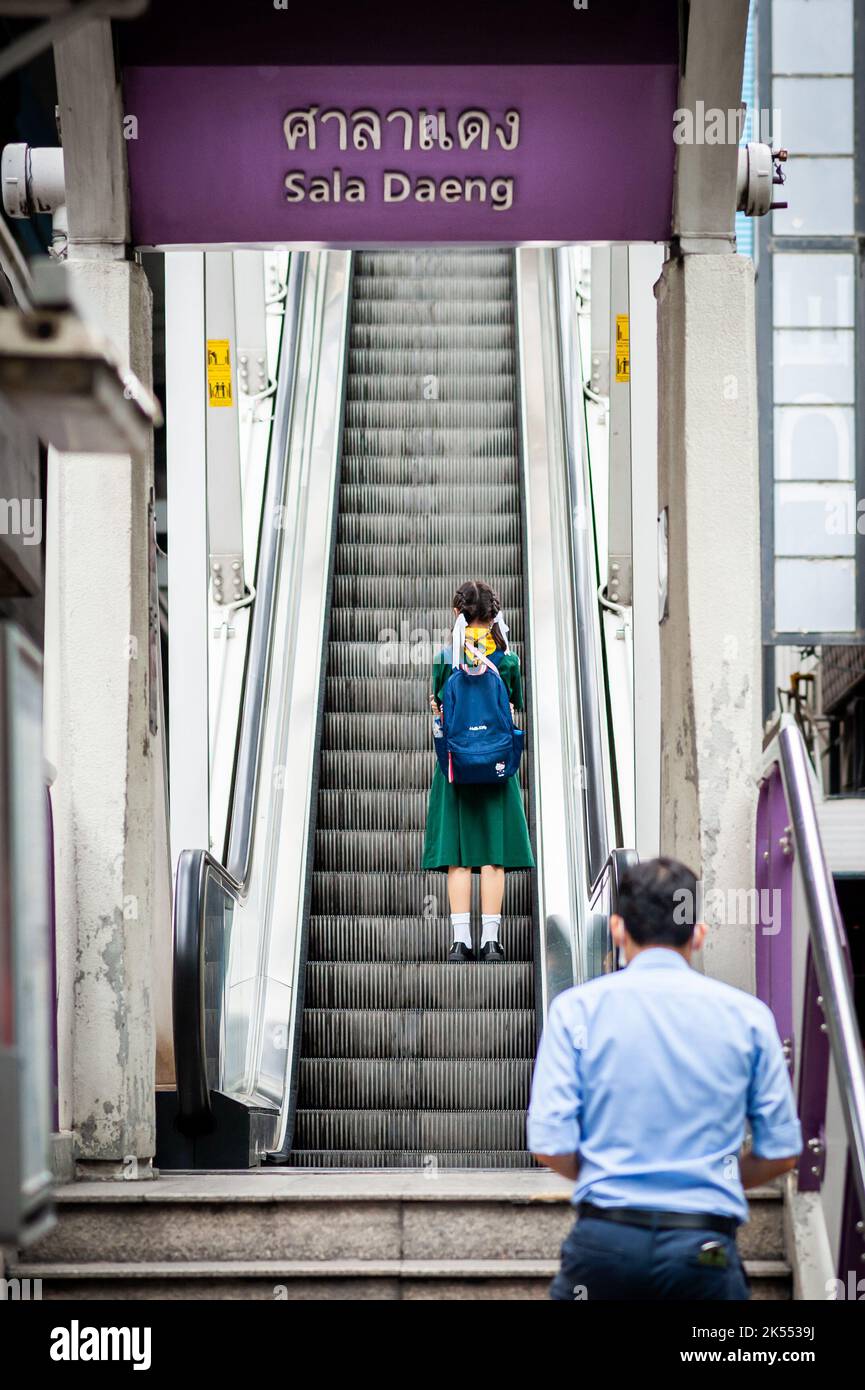 Thai school girls leaving school ascend the escalator at the BTS sky ...