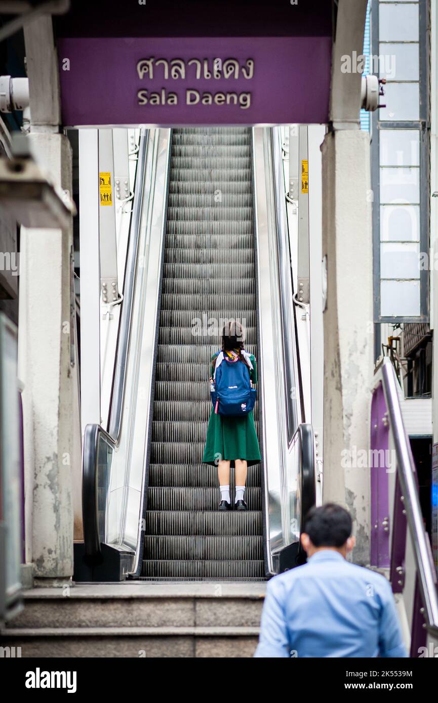 Thai school girls leaving school ascend the escalator at the BTS sky ...