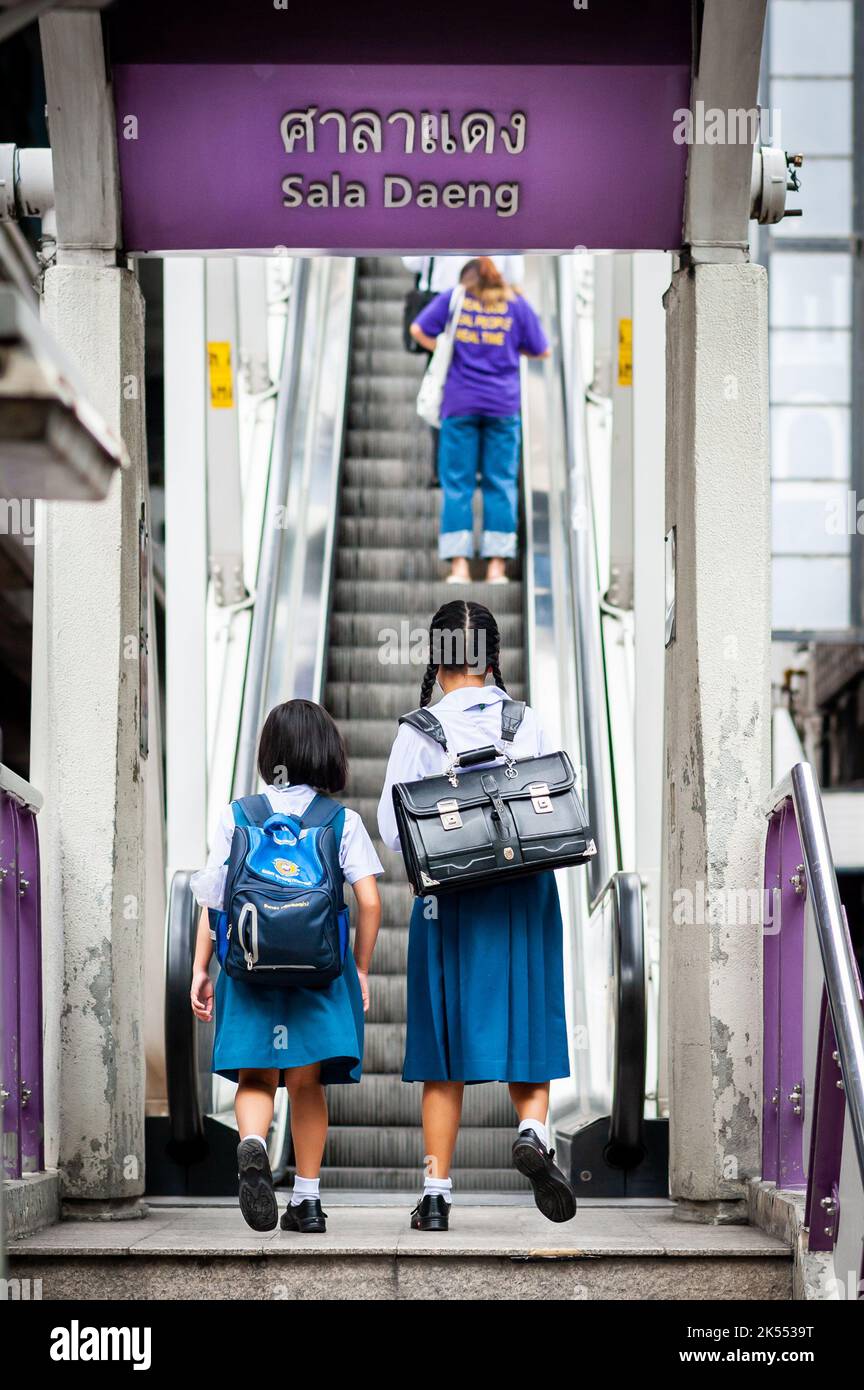 Thai school girls leaving school ascend the escalator at the BTS sky ...