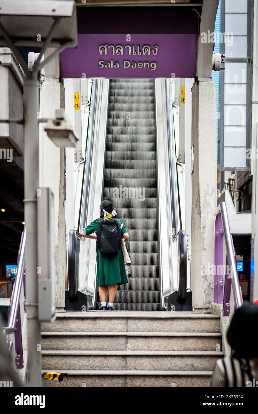 Thai school girls leaving school ascend the escalator at the BTS sky ...