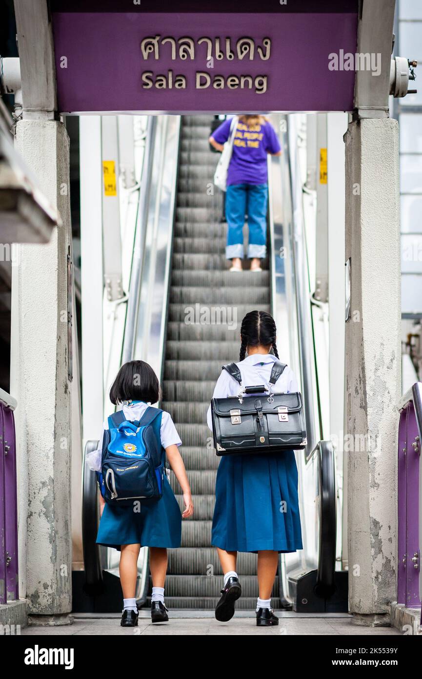 Thai school girls leaving school ascend the escalator at the BTS sky ...