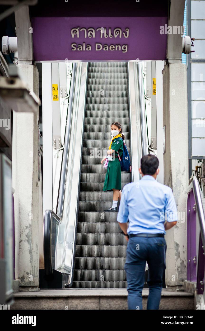 Thai school girls leaving school ascend the escalator at the BTS sky ...