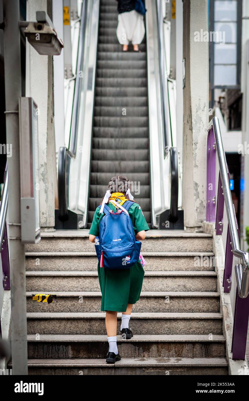 Thai school girls leaving school ascend the escalator at the BTS sky ...