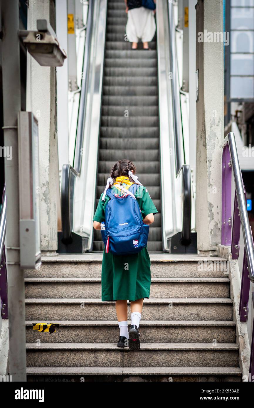 Thai school girls leaving school ascend the escalator at the BTS sky ...