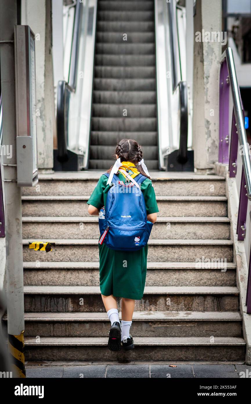 Thai school girls leaving school ascend the escalator at the BTS sky ...