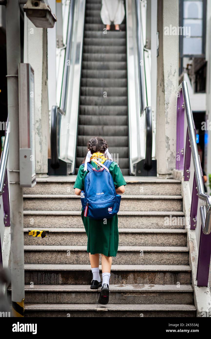 Thai school girls leaving school ascend the escalator at the BTS sky ...