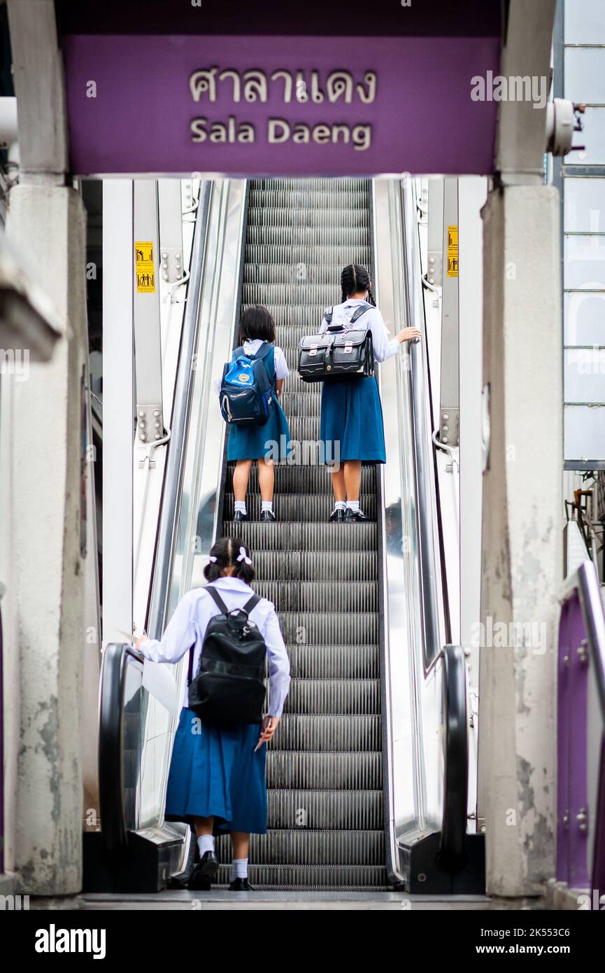 Thai school girls leaving school ascend the escalator at the BTS sky ...