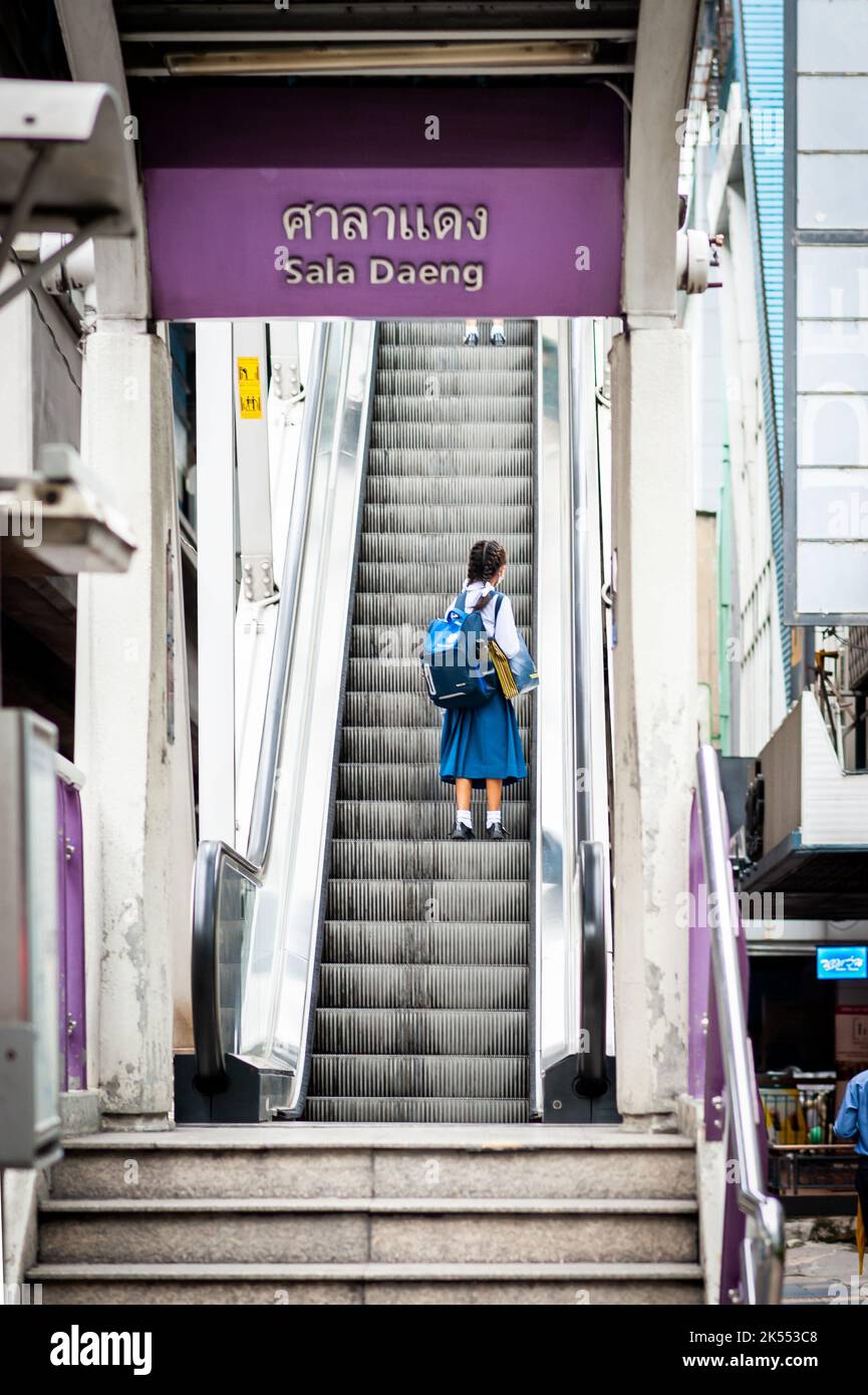 Thai school girls leaving school ascend the escalator at the BTS sky ...