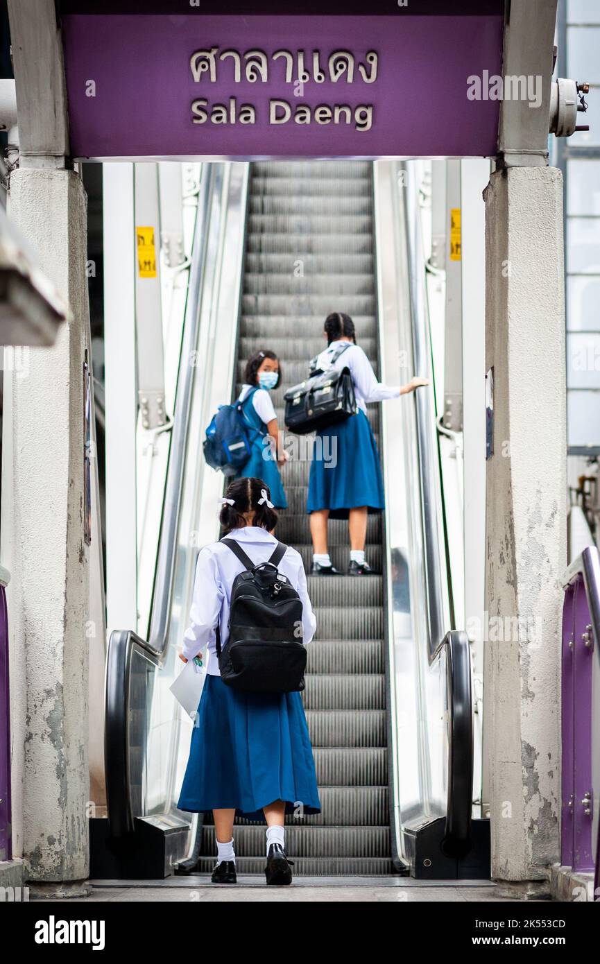 Thai school girls leaving school ascend the escalator at the BTS sky ...