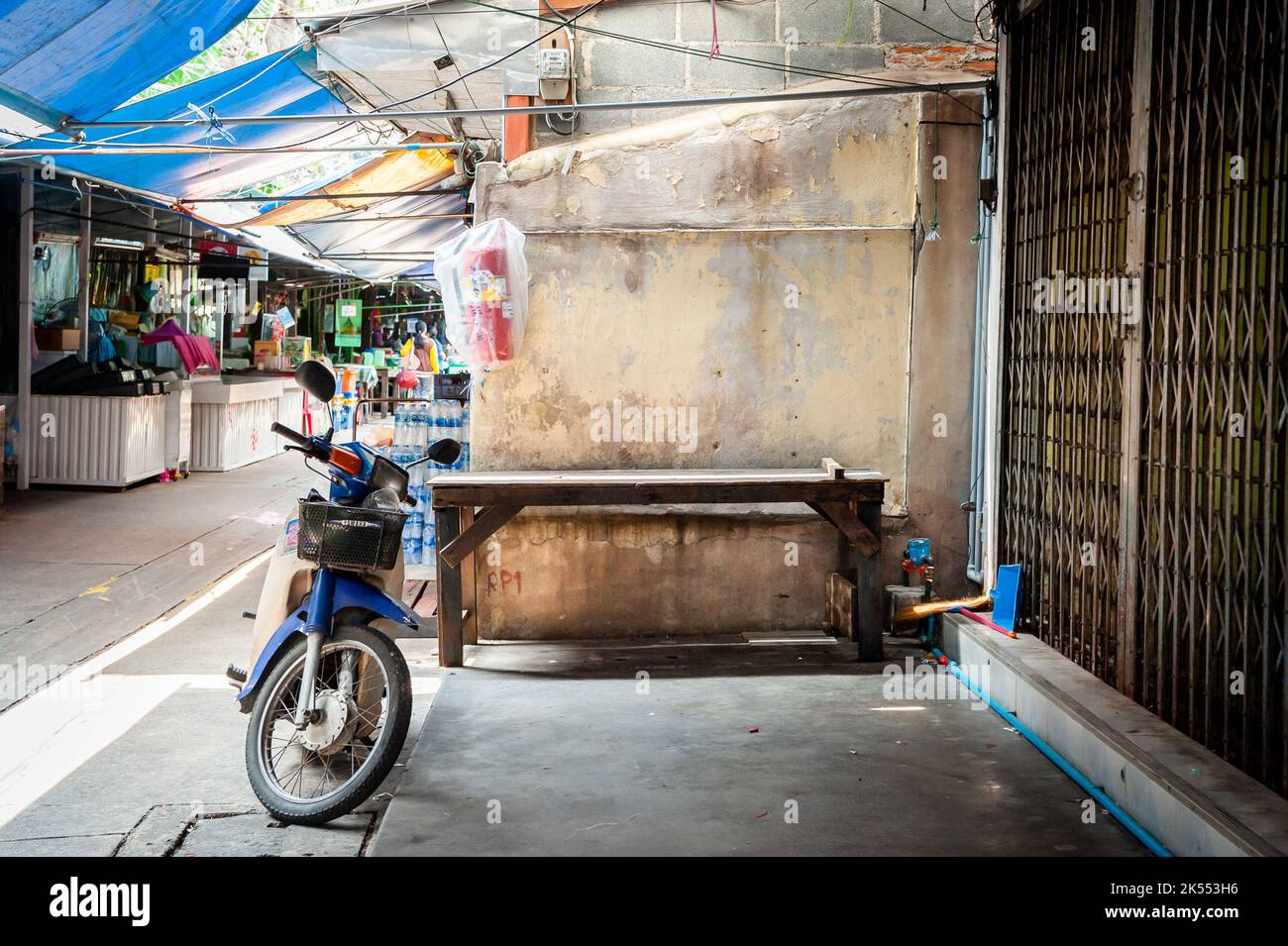 An empty bench sits outside a house in the tight streets of the market ...