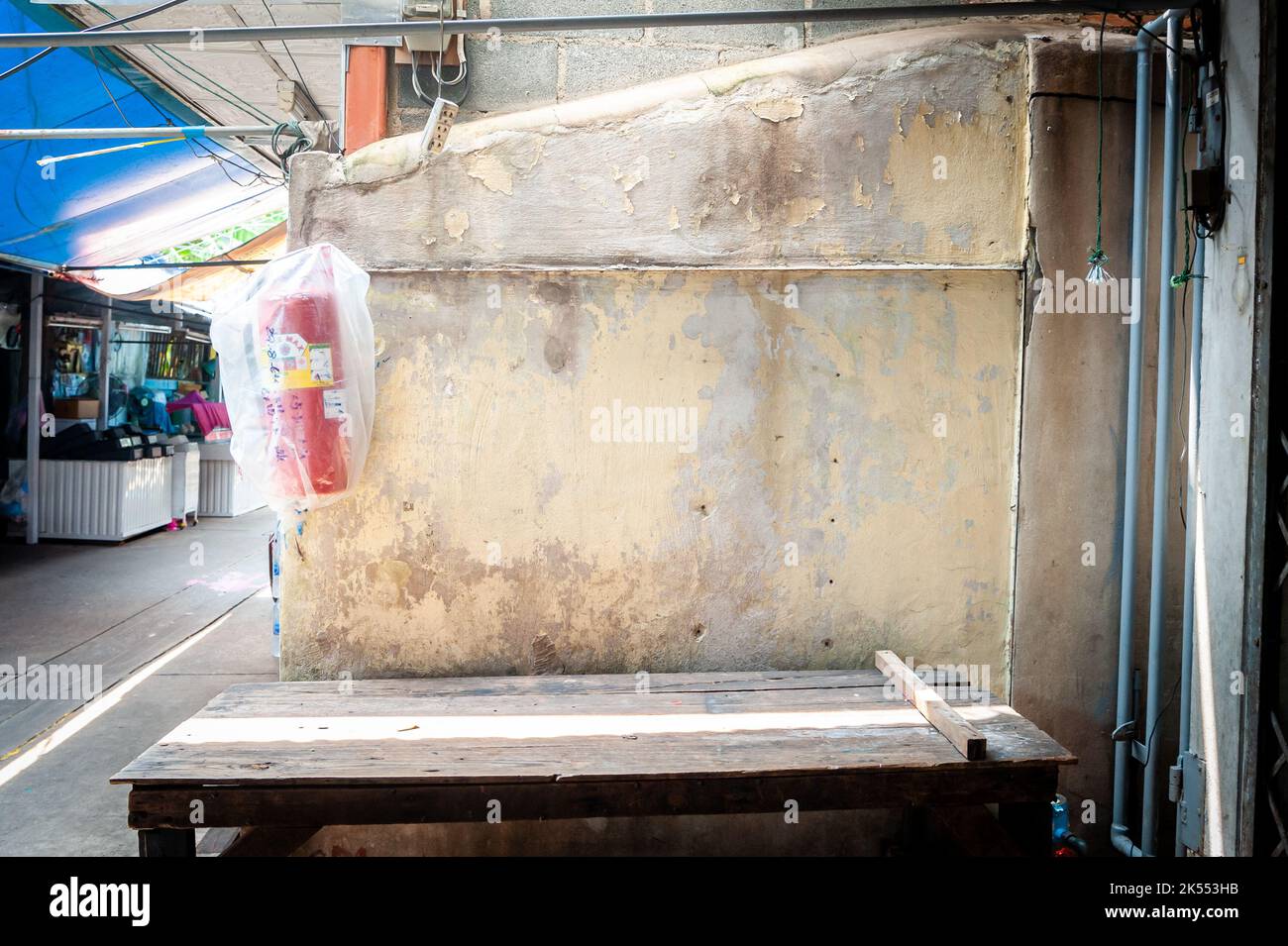 An empty bench sits outside a house in the tight streets of the market ...