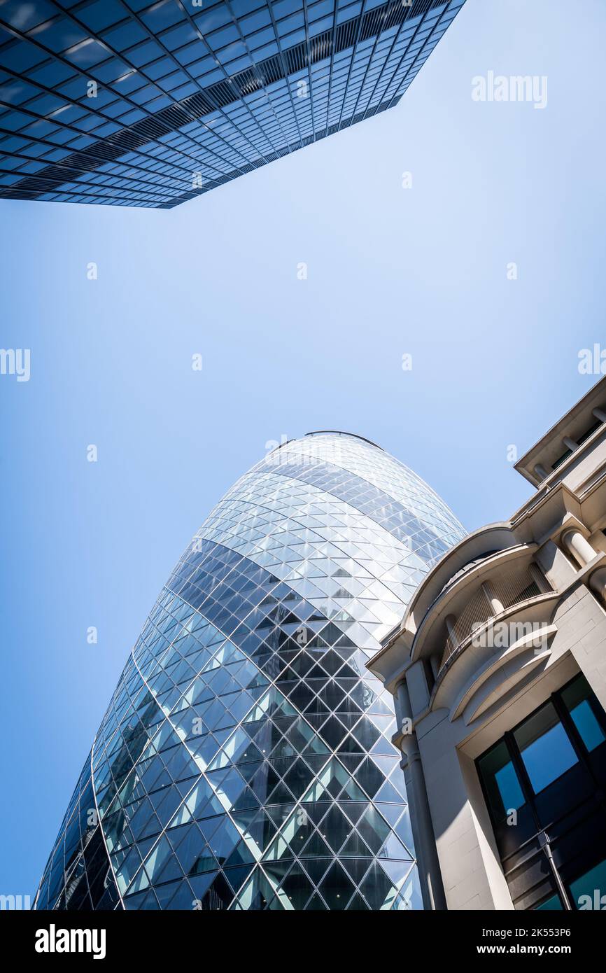 The glass Gherkin Building looms up and shines bright from the street ...