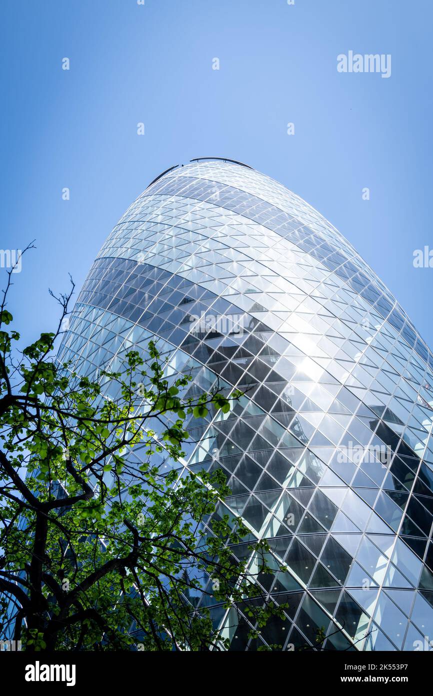 The glass Gherkin Building looms up and shines bright from the street ...