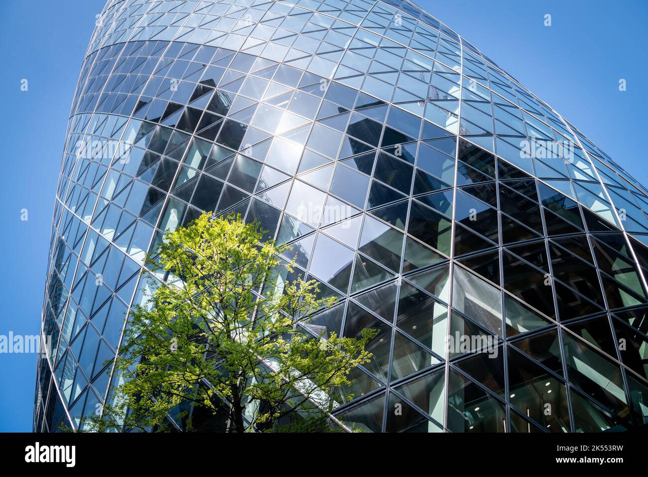 The glass Gherkin Building looms up and shines bright from the street ...