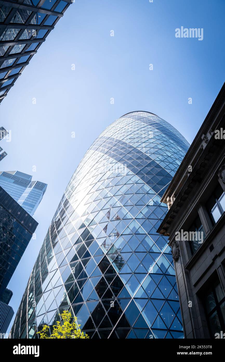 The glass Gherkin Building looms up and shines bright from the street ...