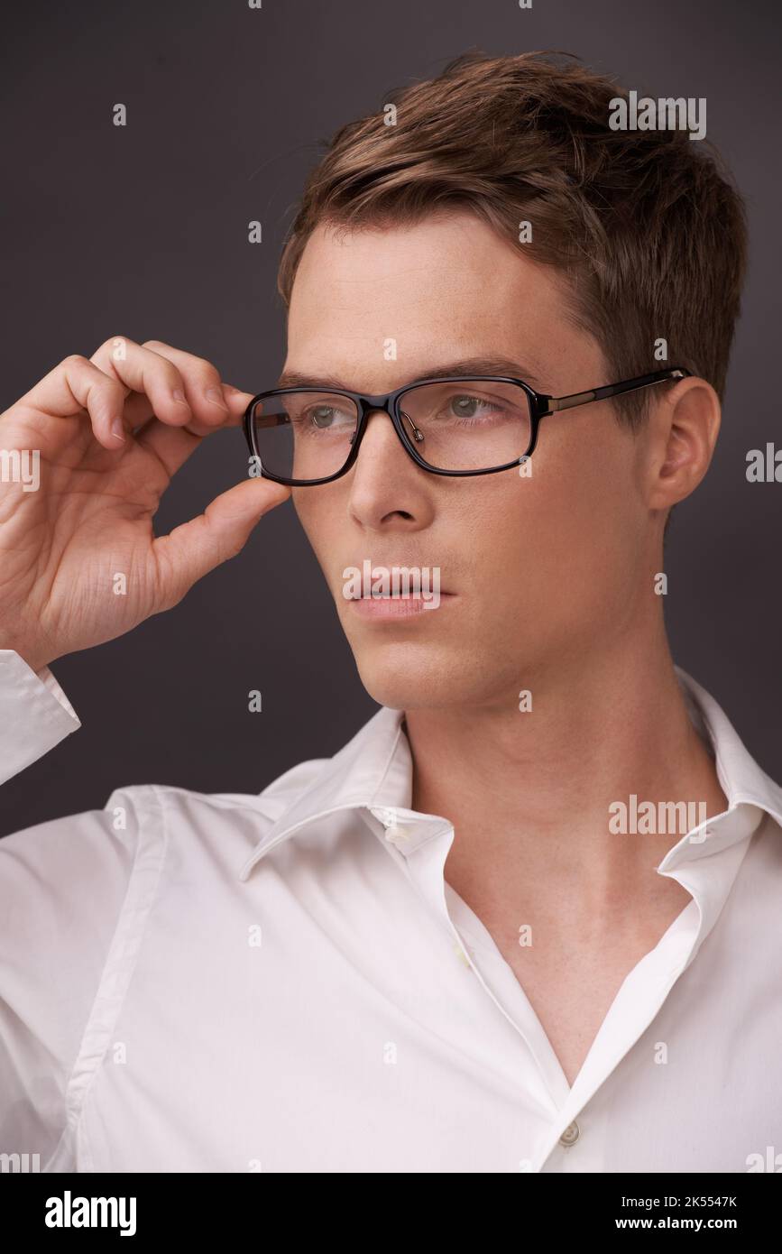 Adjusting his spectacles. Closeup of a handsome young man touching the ...