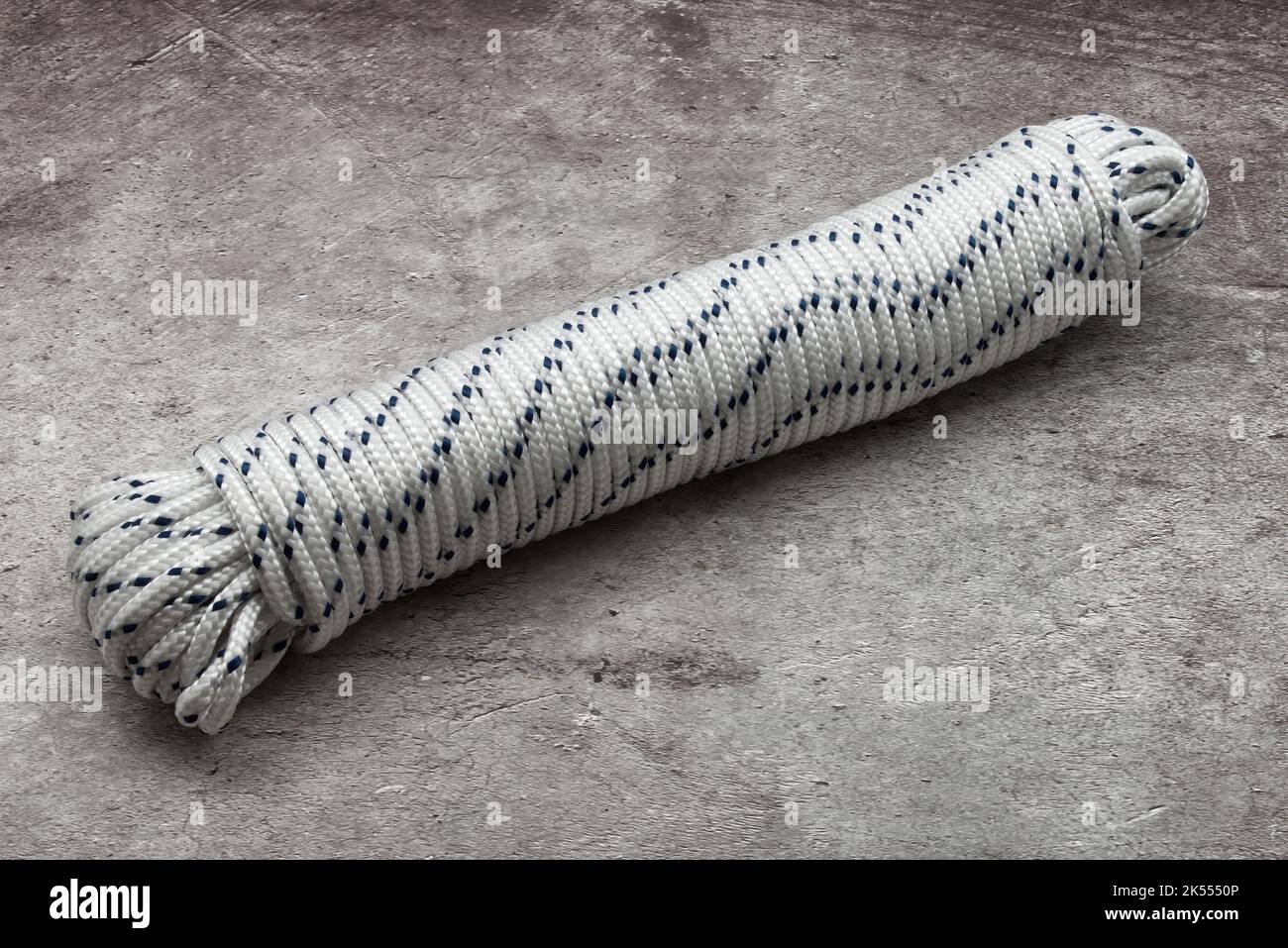 White braided polypropylene rope 16 strands isolated on concrete ...