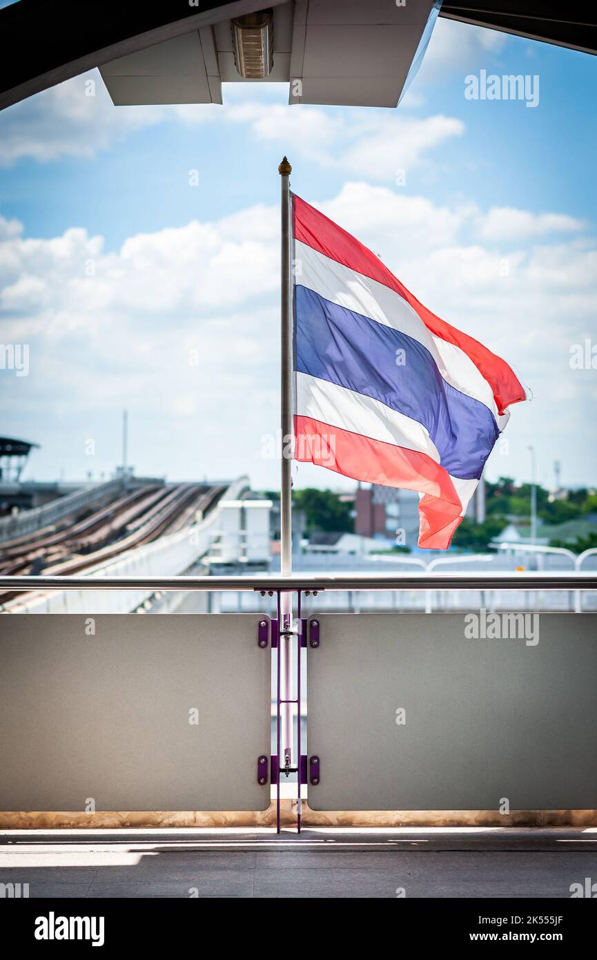 The Thai national flag flies in the wind on the platform of one of ...