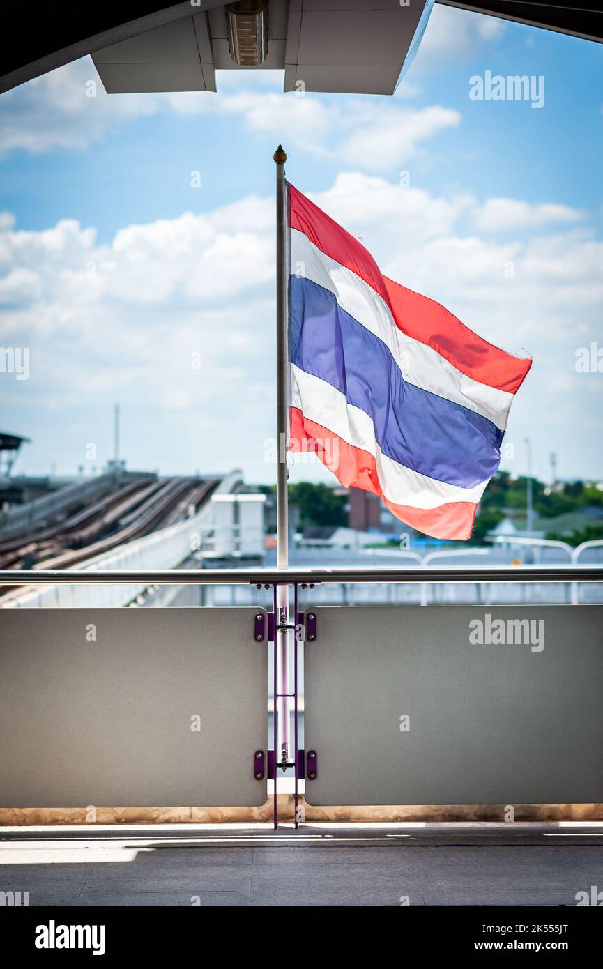 The Thai national flag flies in the wind on the platform of one of ...