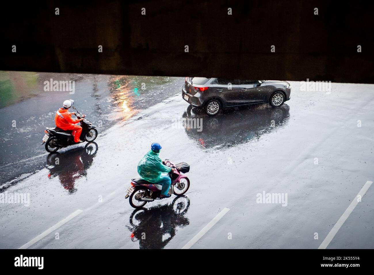 Cars, vans, buses and motorbikes all pass along a busy intersection on ...