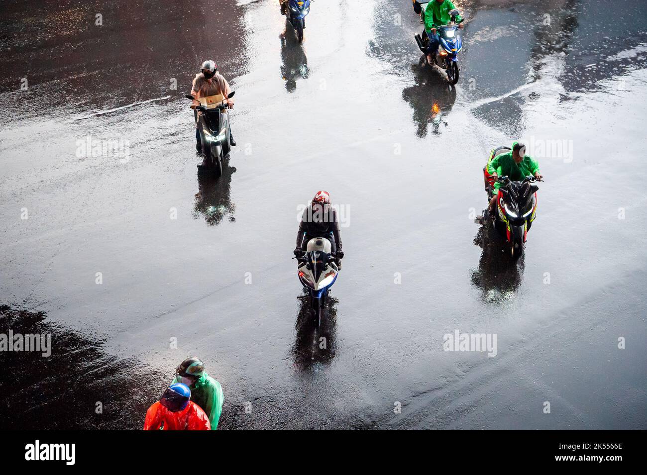 Cars, vans, buses and motorbikes all pass along a busy intersection on ...