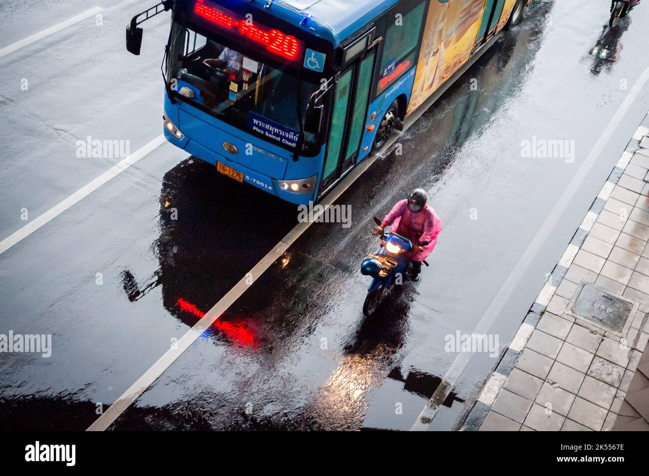 Cars, vans, buses and motorbikes all pass along a busy intersection on ...