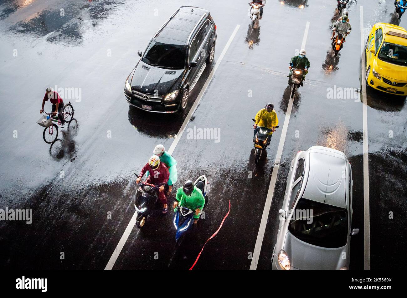 Cars, vans, buses and motorbikes all pass along a busy intersection on ...
