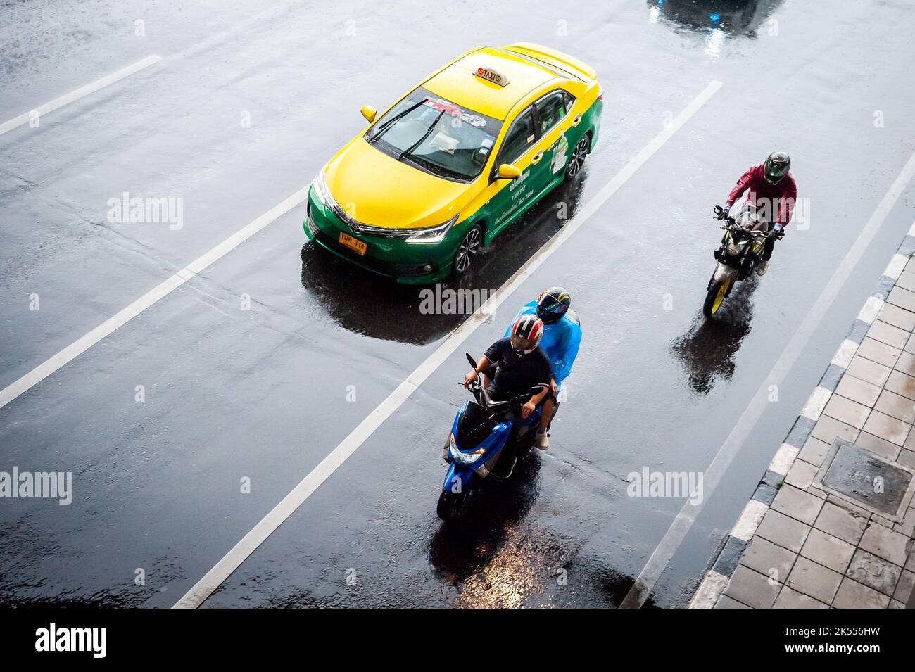 Cars, vans, buses and motorbikes all pass along a busy intersection on ...