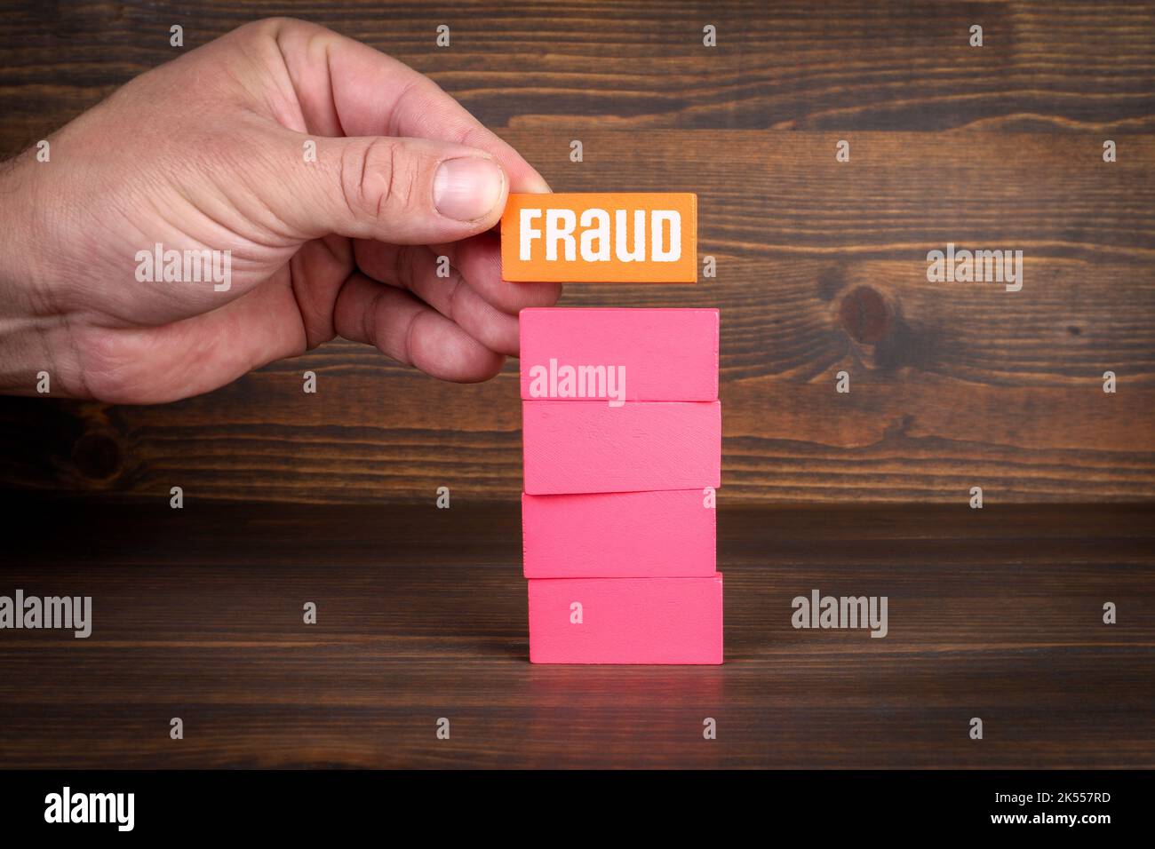 Fraud concept. Colorful wooden blocks in a pile on a textured ...