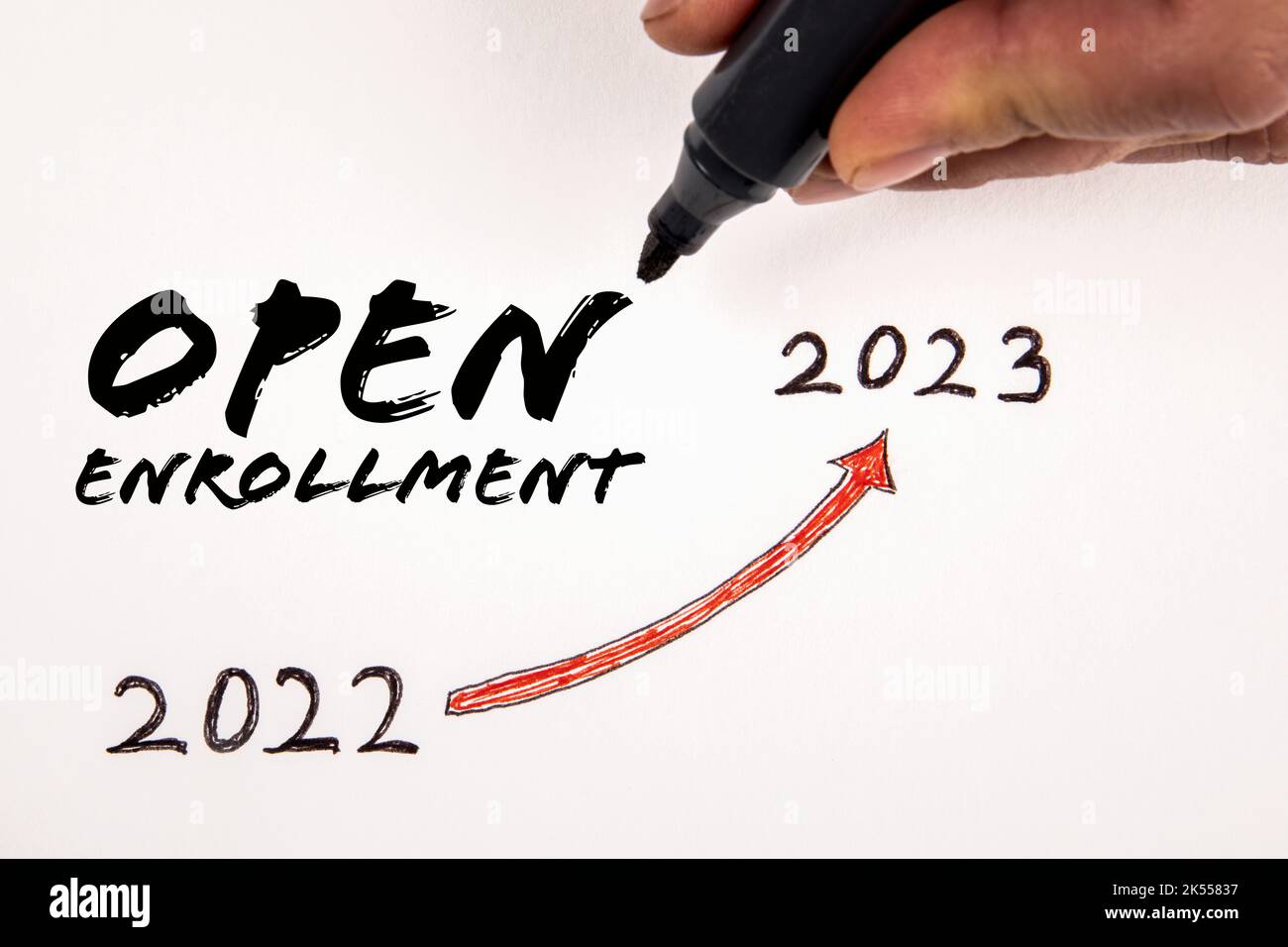 Open Enrollment. Text and a man's hand holding a black marker on a ...