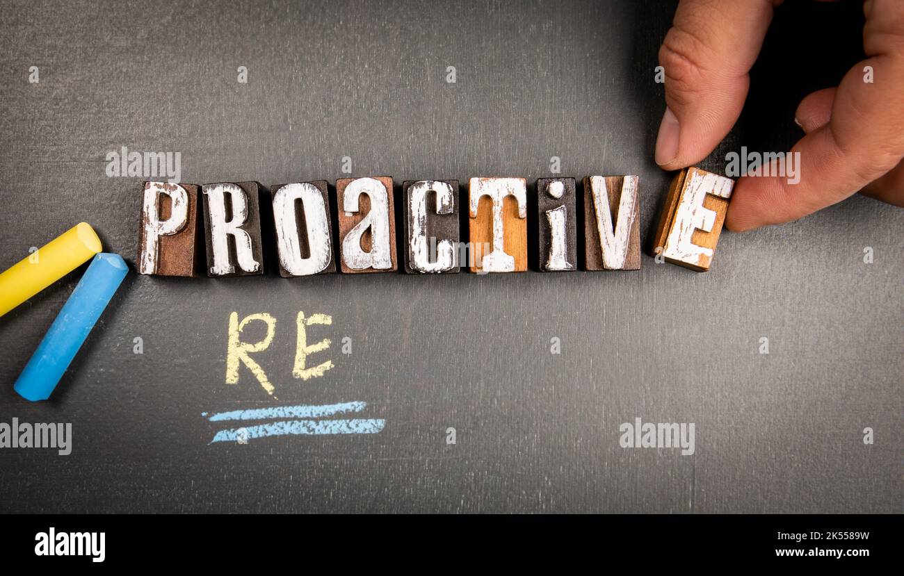 Proactive and Reactive concept. Wooden letter blocks and colored chalk ...