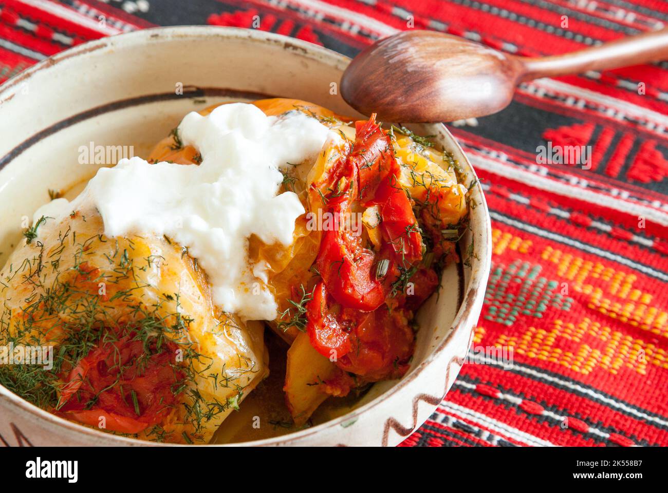 delicious minced meat stuffed bell peppers in a clay bowl with wooden ...