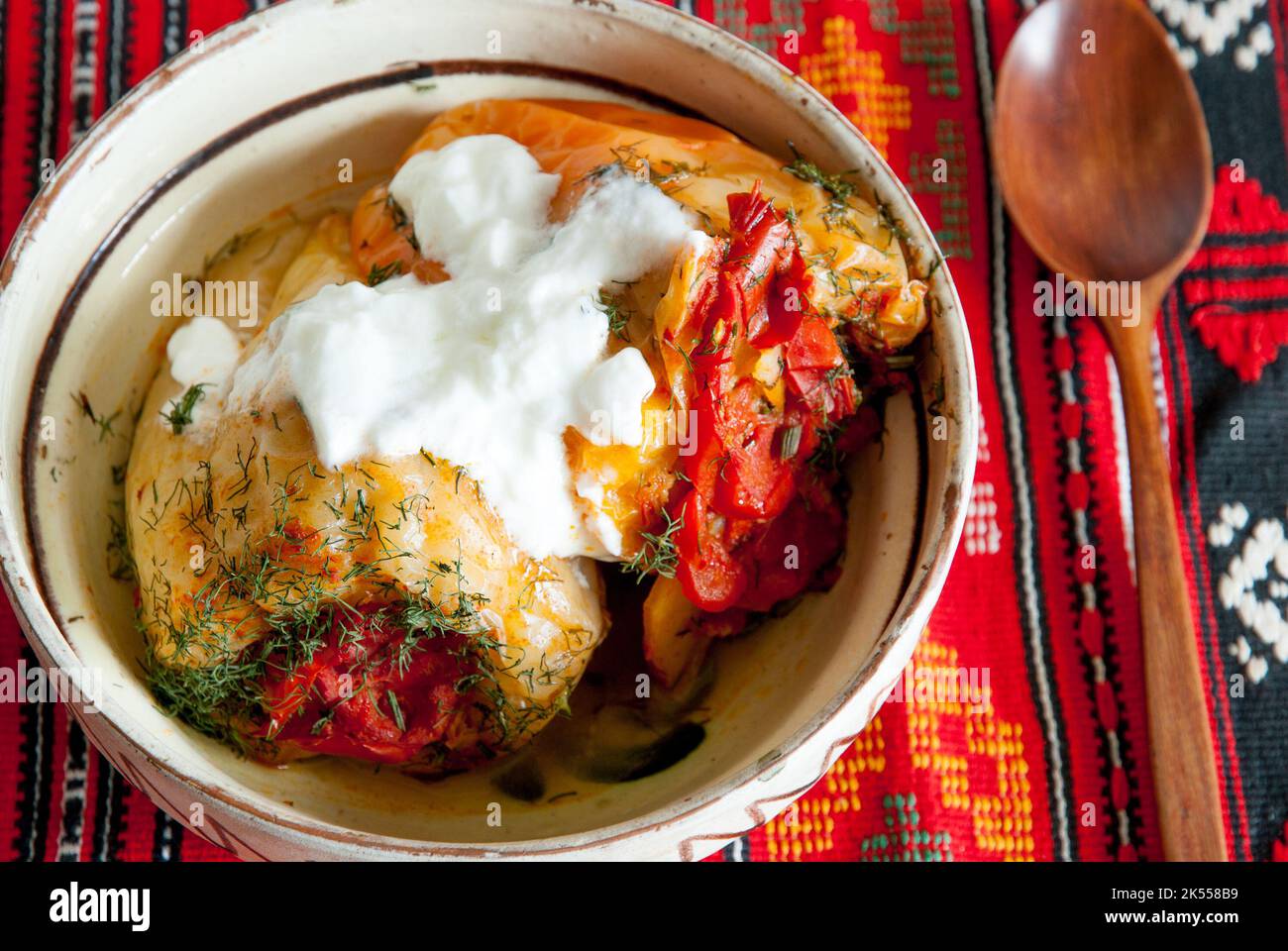 delicious minced meat stuffed bell peppers in a clay bowl with wooden ...