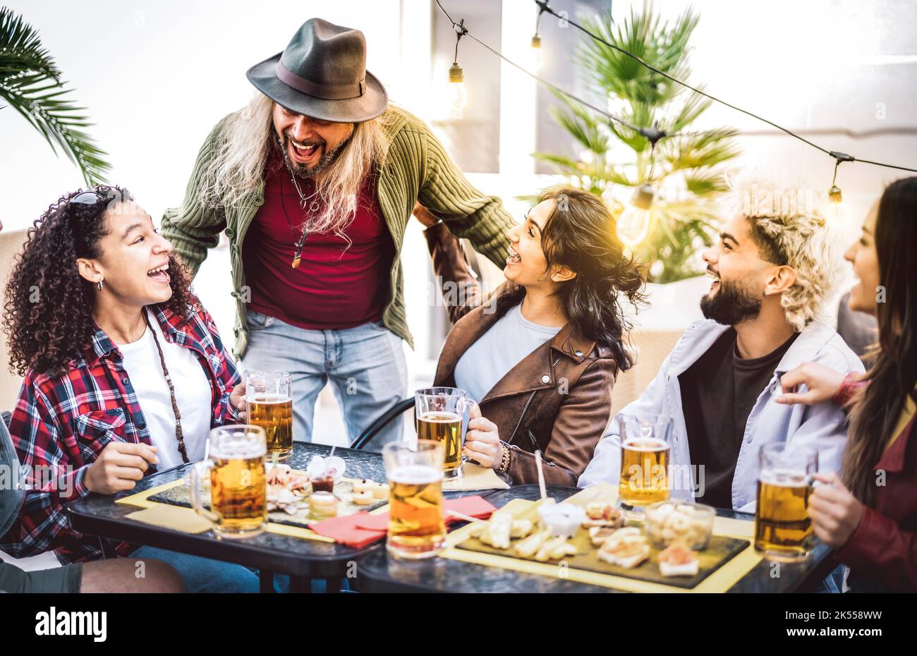 Multiracial guys and girls drinking beer pints at balcony patio - Youth ...