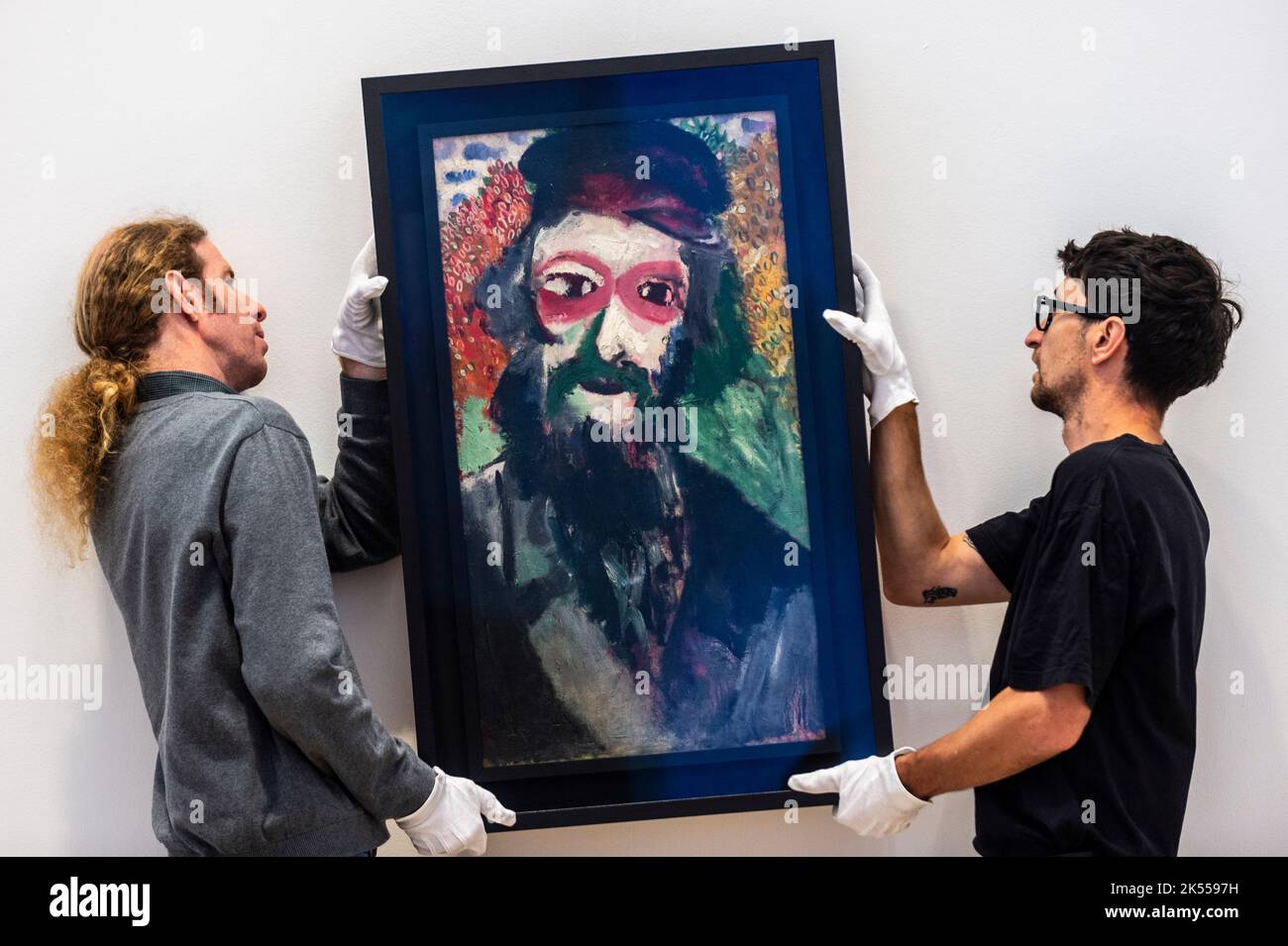 London, UK. 6 October 2022. Technicians hang Marc Chagall’s “Portrait ...