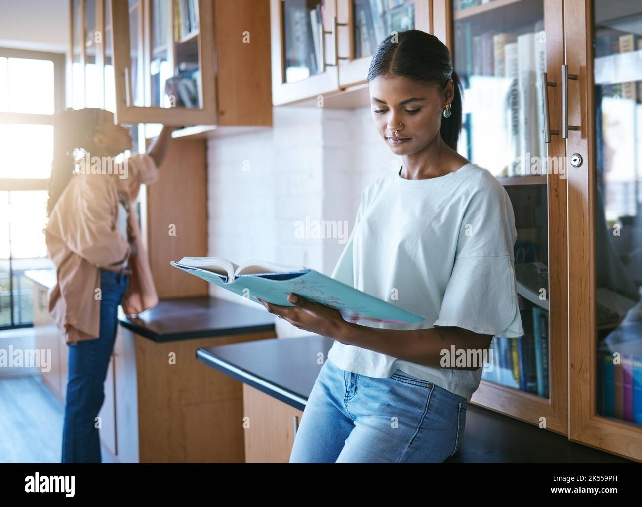Student, college library and books with woman reading from shelf for ...