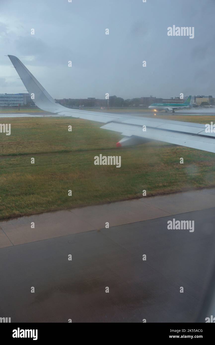 View through an aeroplanes window at with rain streaming across the ...