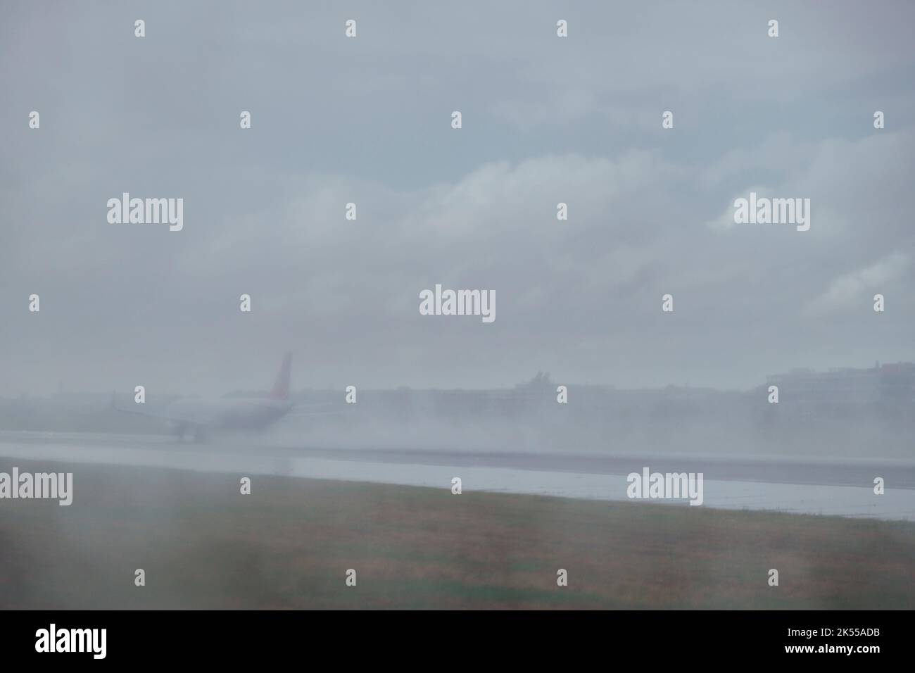 View through an aeroplanes window at with rain streaming across the ...