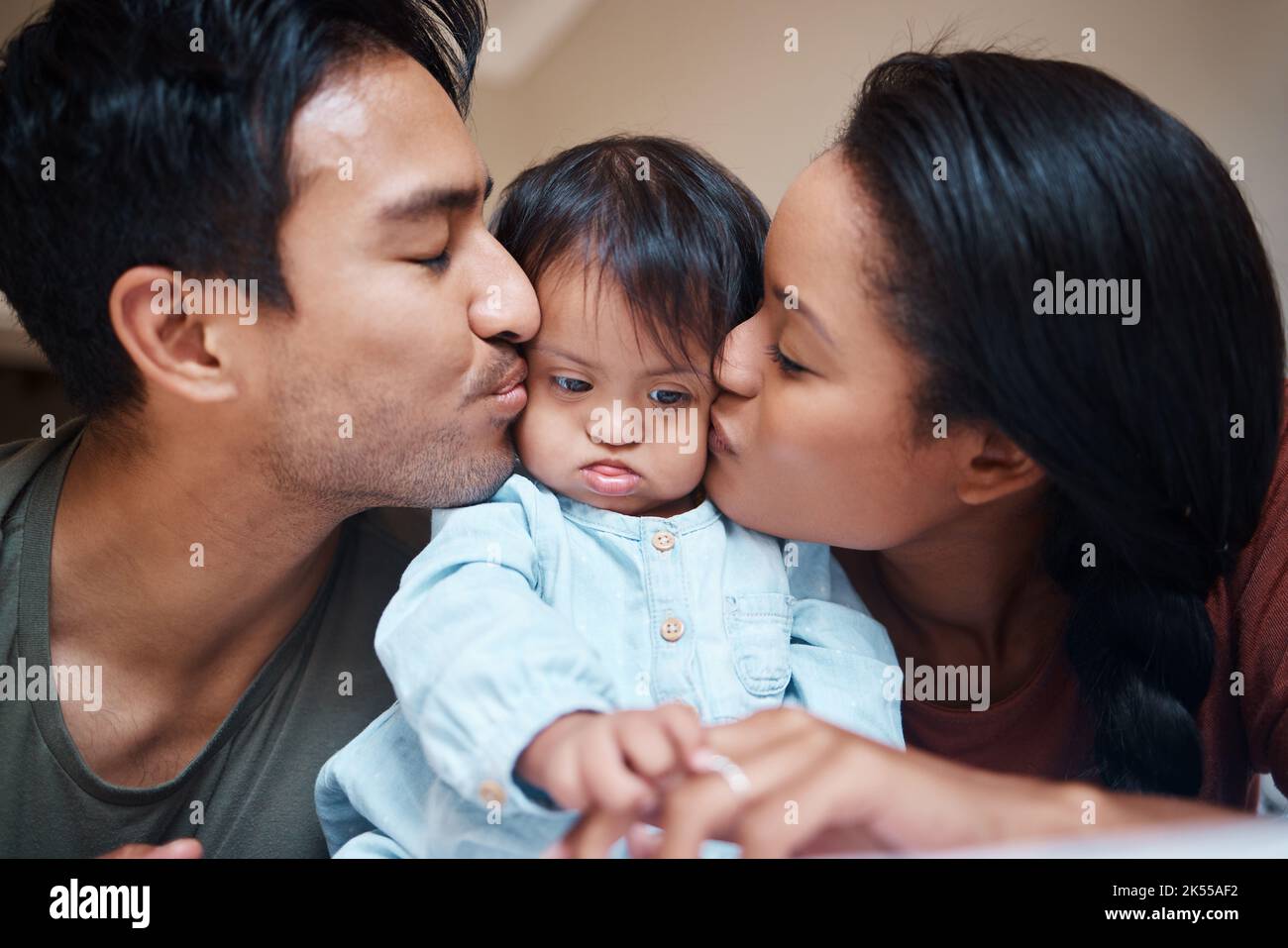 Love, disability and down syndrome parents kiss special needs kid with ...