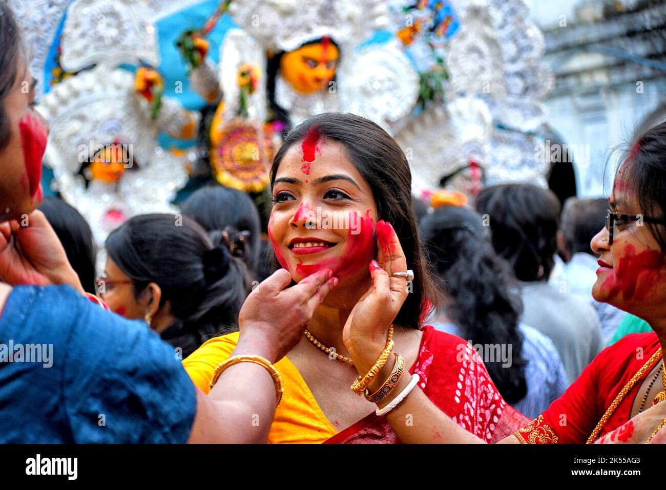 An Indian Hindu devotee smiles while being smeared with vermillion ...