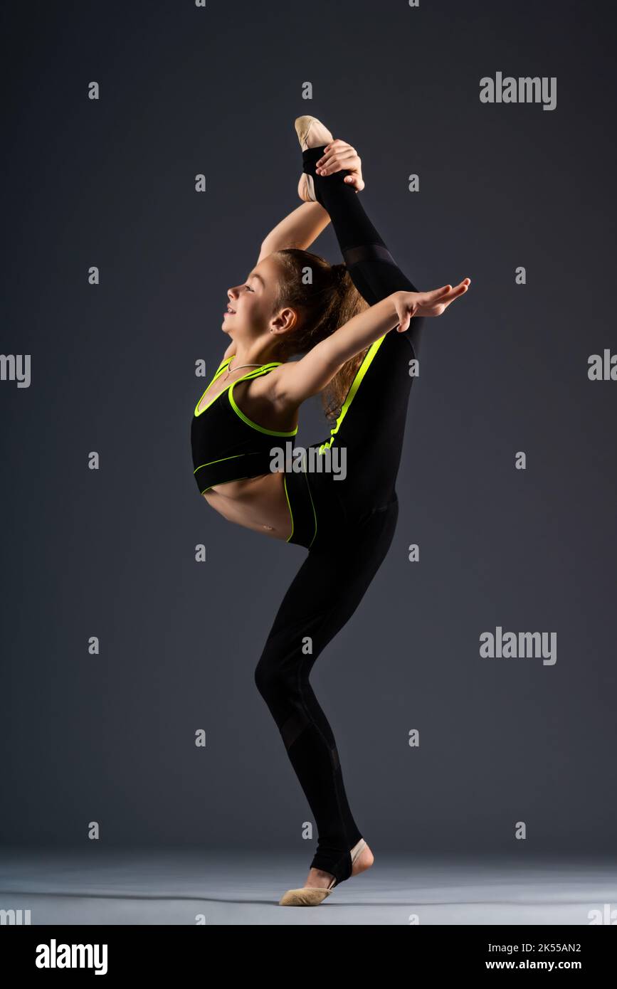 Young gymnast. A teenage girl in a tracksuit is engaged in gymnastics ...