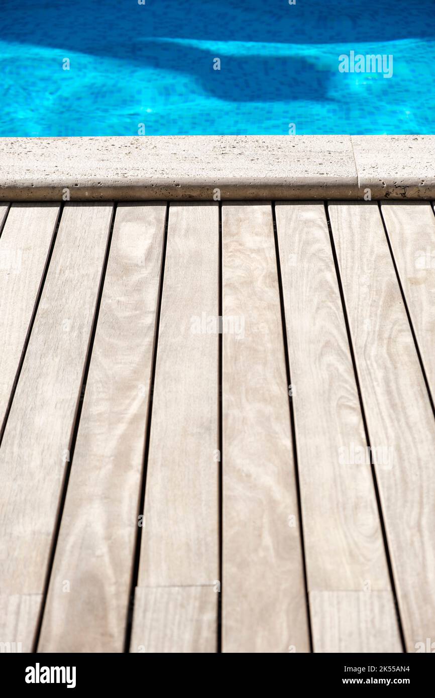 Wooden boards on the side of a deep blue swimming pool Stock Photo - Alamy