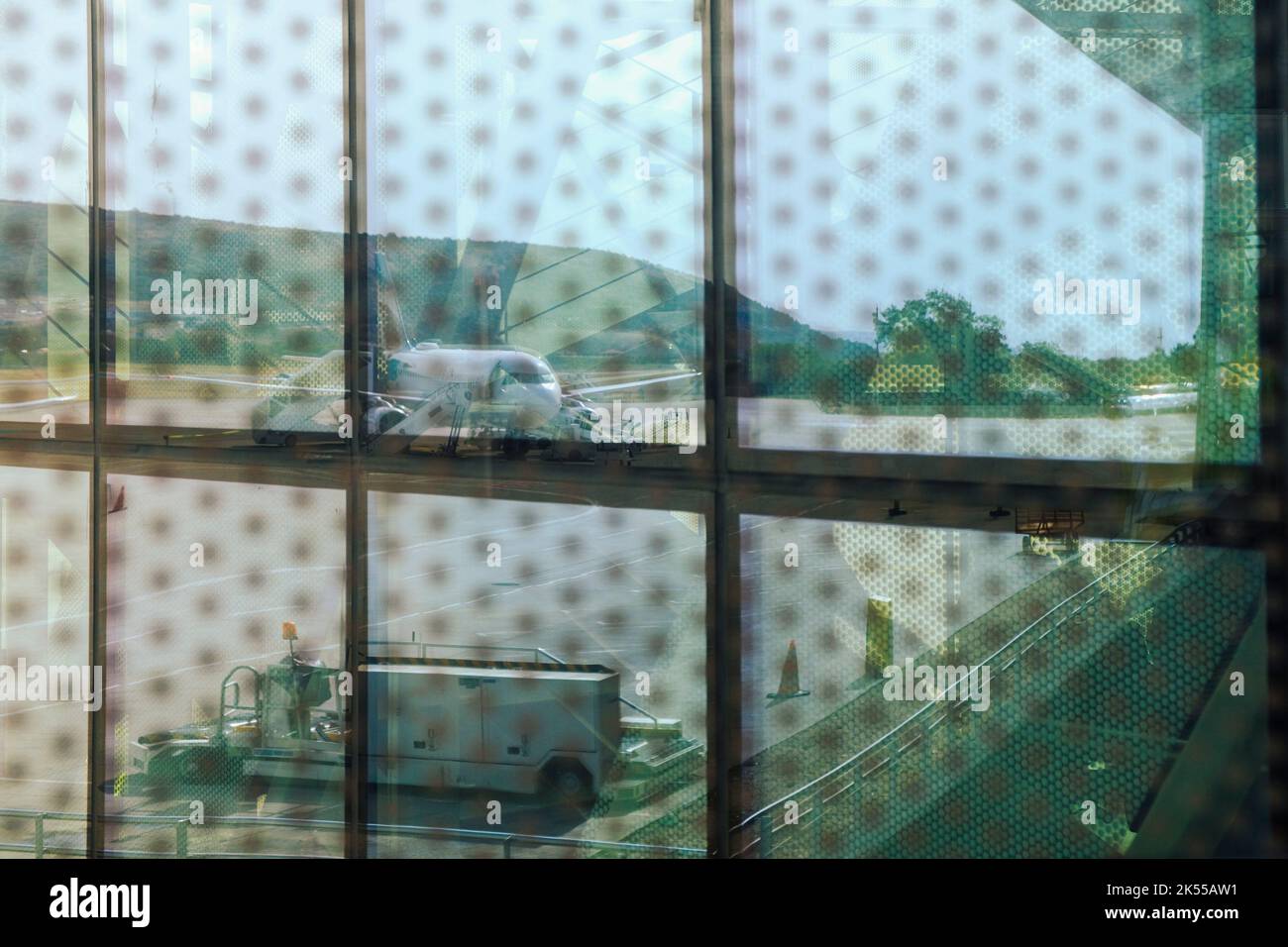 Looking through a window that obsucres jet aircraft on the departure ...