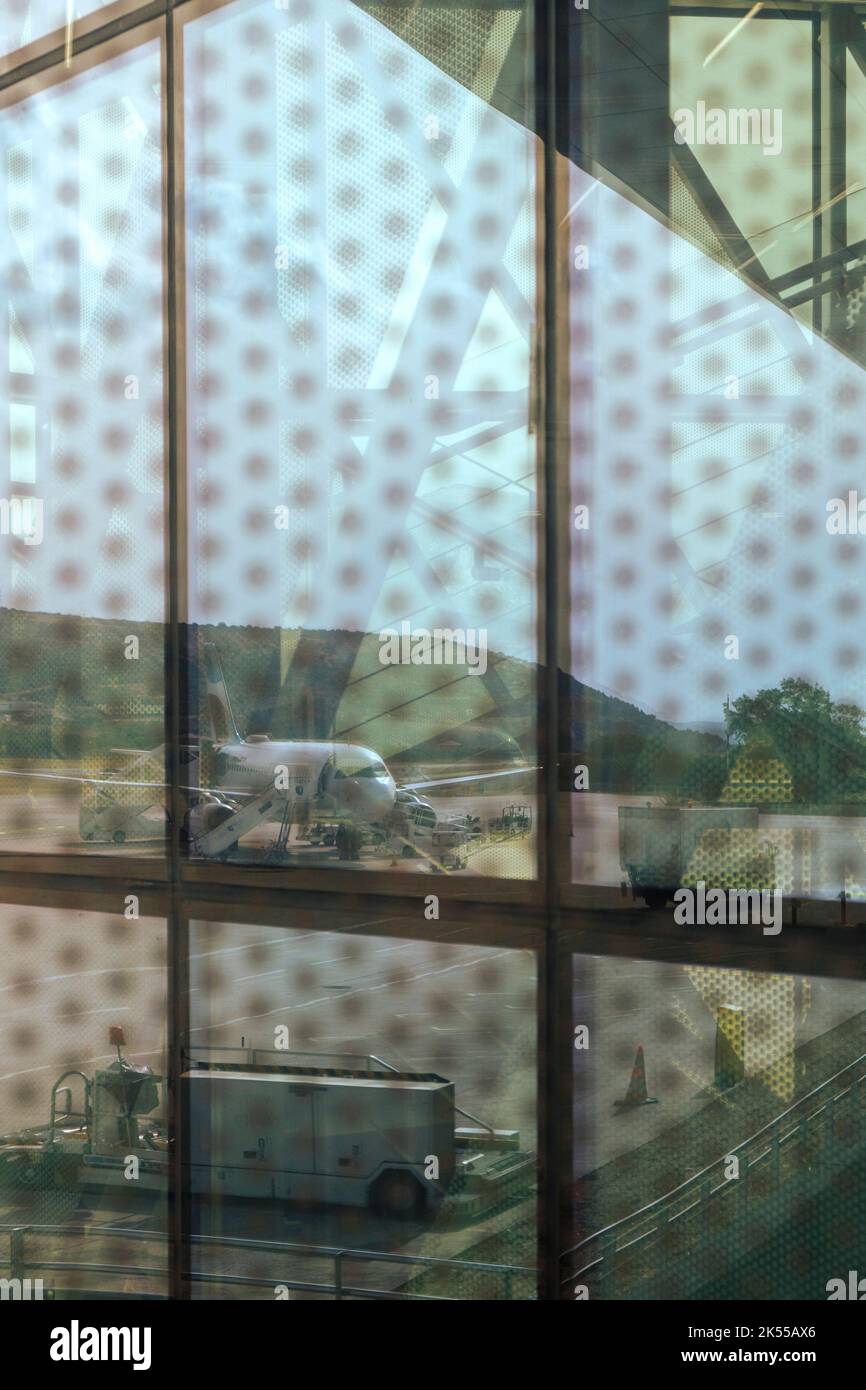 Looking through a window that obsucres jet aircraft on the departure ...