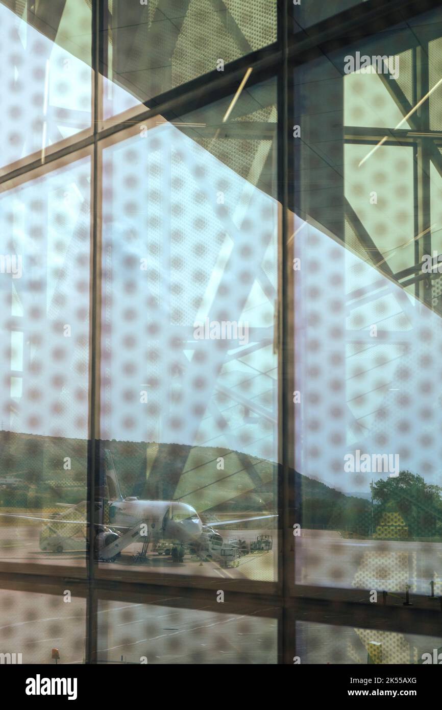 Looking through a window that obsucres jet aircraft on the departure ...