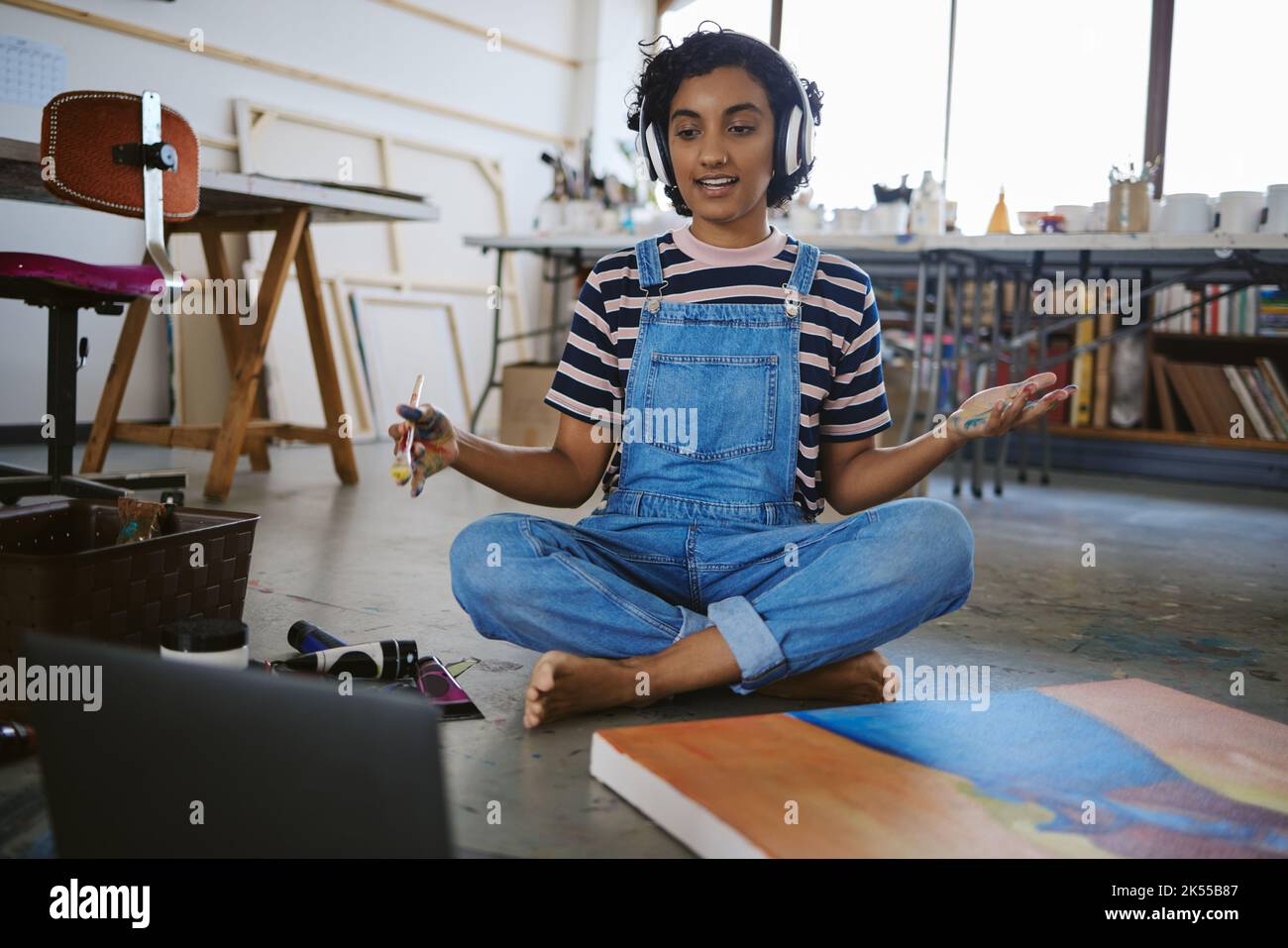 Painter girl and laptop video call with headphones for concentration ...