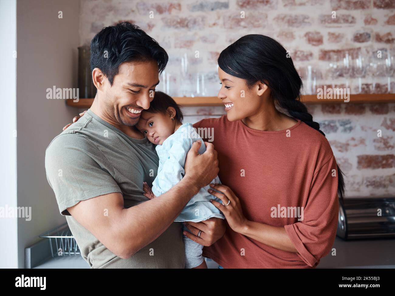 Down syndrome, happy family and baby in a kitchen, bonding and ...